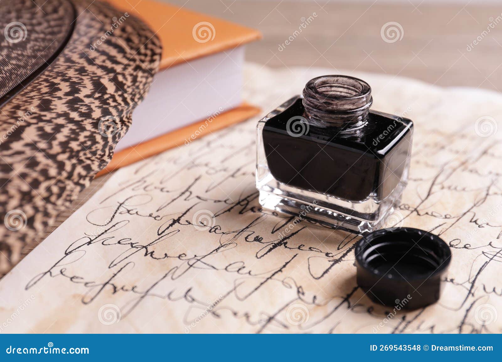 Open Inkwell, Feather, Book and Vintage Parchment with Text on Table ...