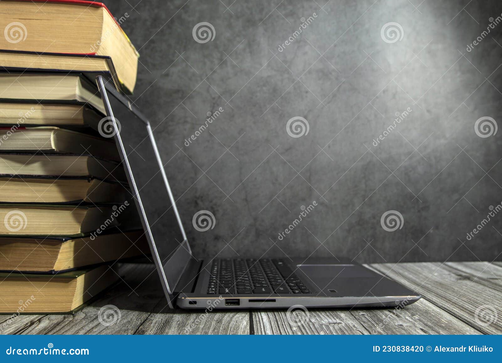 An Open Laptop on the Table Near the Stack of Books. Stock Photo ...