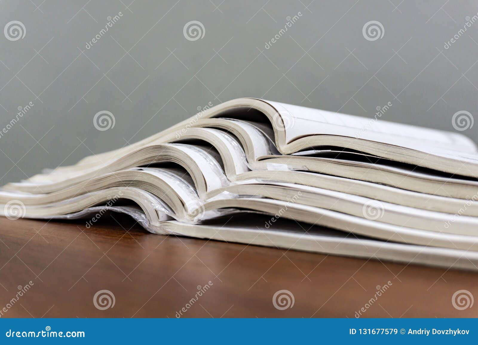 Open Magazines Lie on Top of Each Other on a Brown Table, Documents are ...