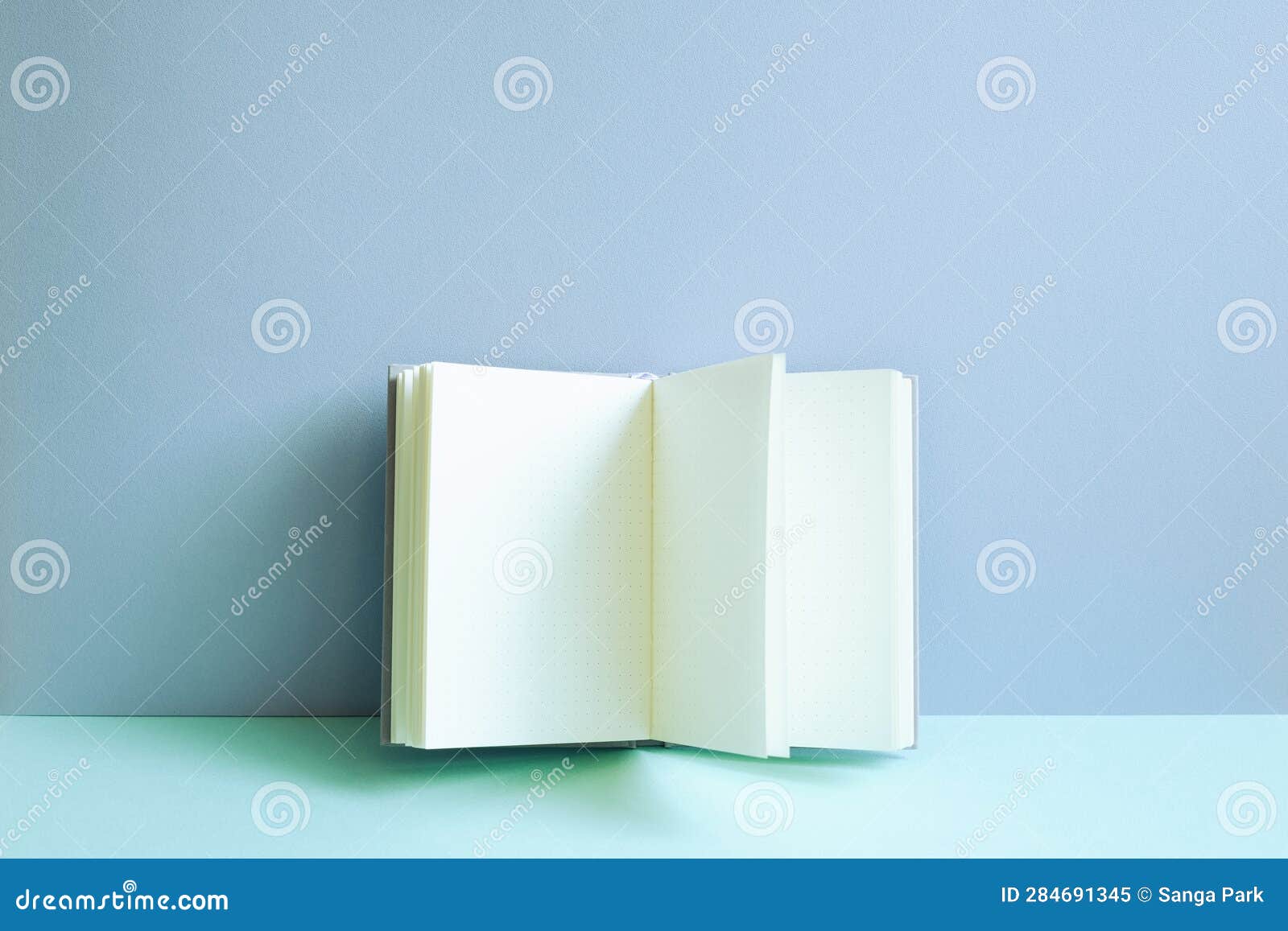 Open Notebook on Blue Desk. Blue Wall Background Stock Image - Image of ...