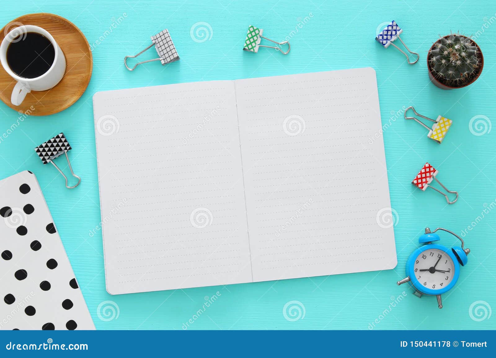 Open Notebook with Empty Pages and Other Office Supplies Over Blue ...