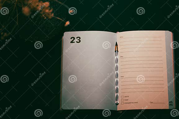 An Open Pad with a Date 23 is Lying on Dark Table Top View. a Notebook ...