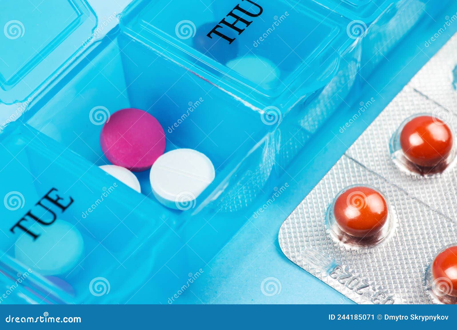 Open Pill Organizer with Pills on Blue Background Stock Image - Image ...