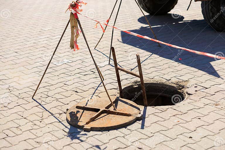 An Open Sewer Hatch during Technical Work. Background with Selective ...