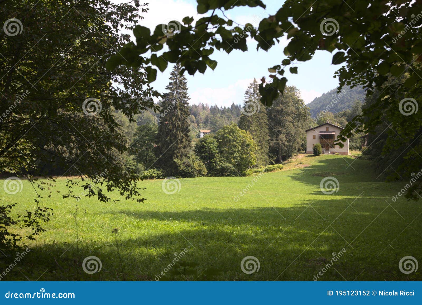 Open Space in the Mountain Framed by Trees with a House in the Distance ...