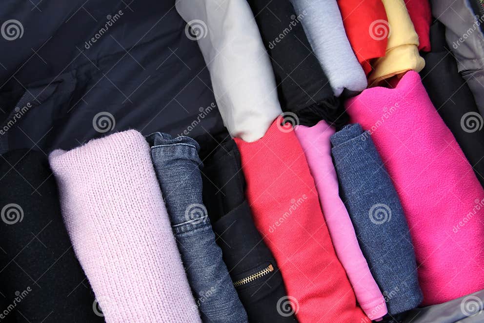 Open Suitcase on the Green Grass with Different Clothes Folded ...