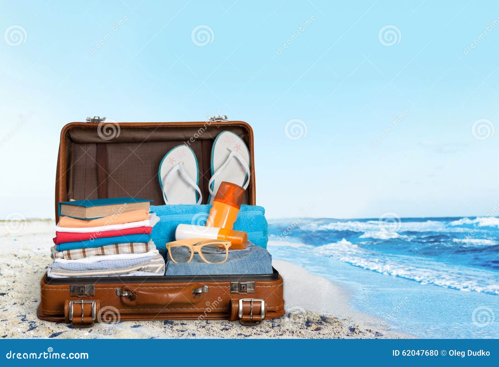 Open Suitcase On The Green Grass With Different Clothes Folded ...