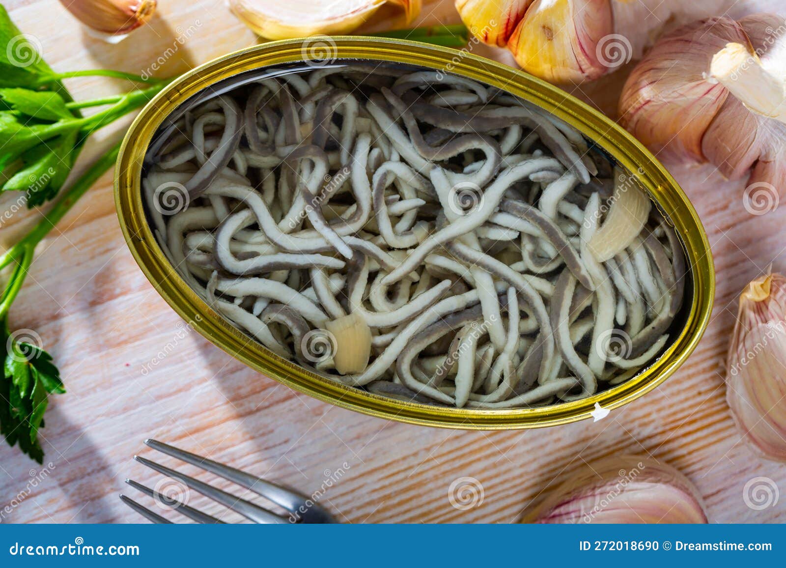 Open Tin Can of Pickled Eels and Garlic with Greens at Table Stock ...