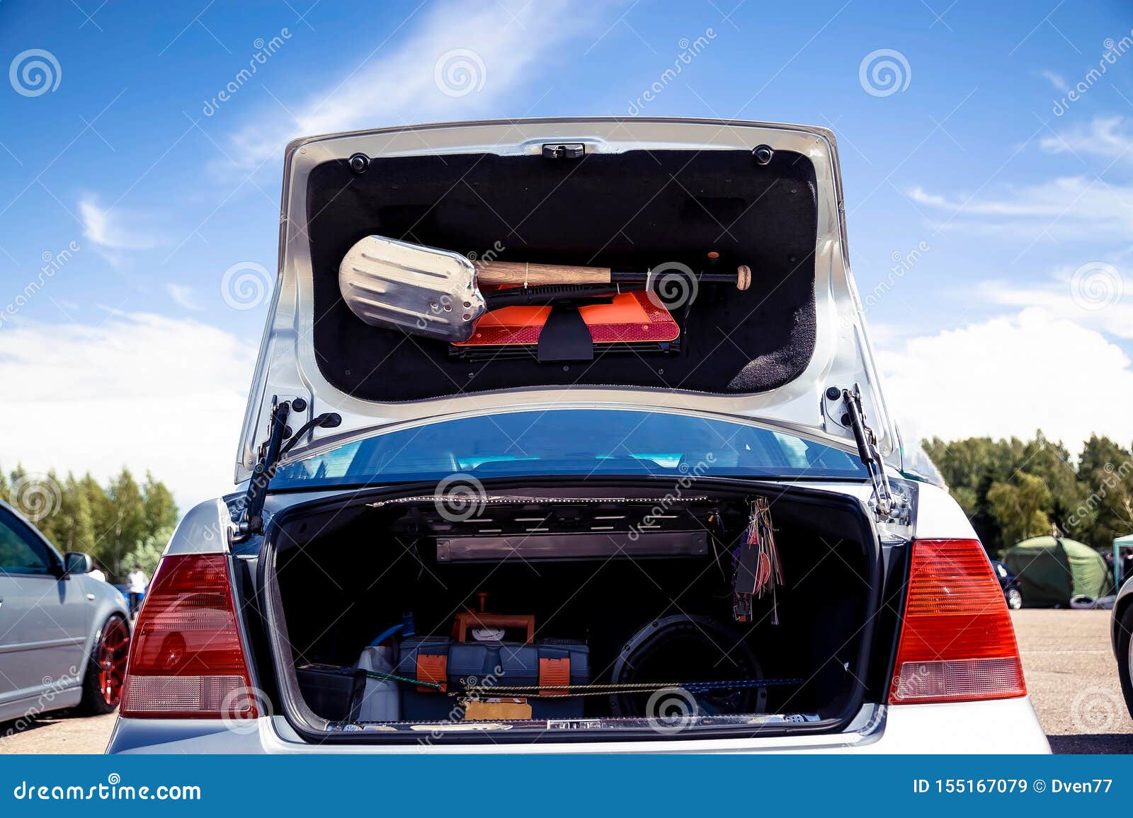 Open The Trunk Of A Silver Car That Stands On The Street. In The Trunk ...