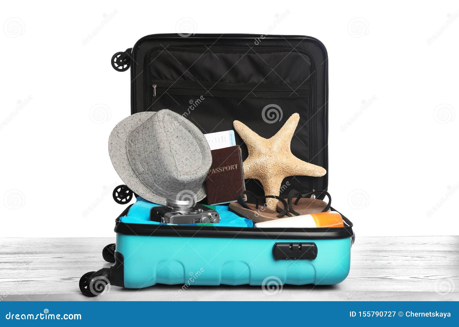 Open Turquoise Suitcase with Beach Objects on Wooden Table, White ...