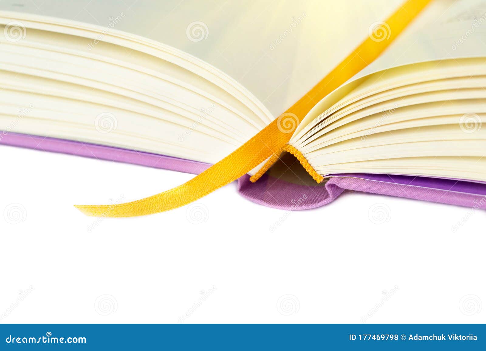 Opened Book with a Bookmark in the Form of a Gold Ribbon Close-up. the ...