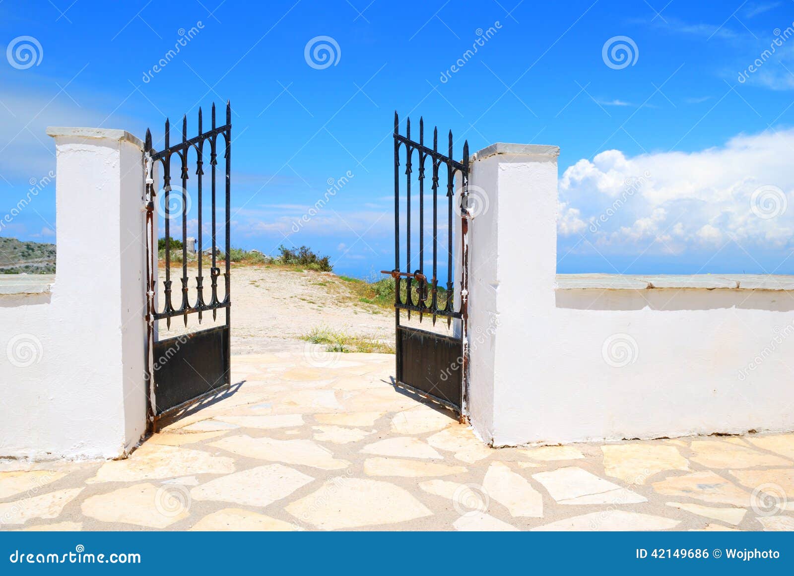 Opened Iron Gate in a White Wall with Blue Sky Stock Photo - Image of ...