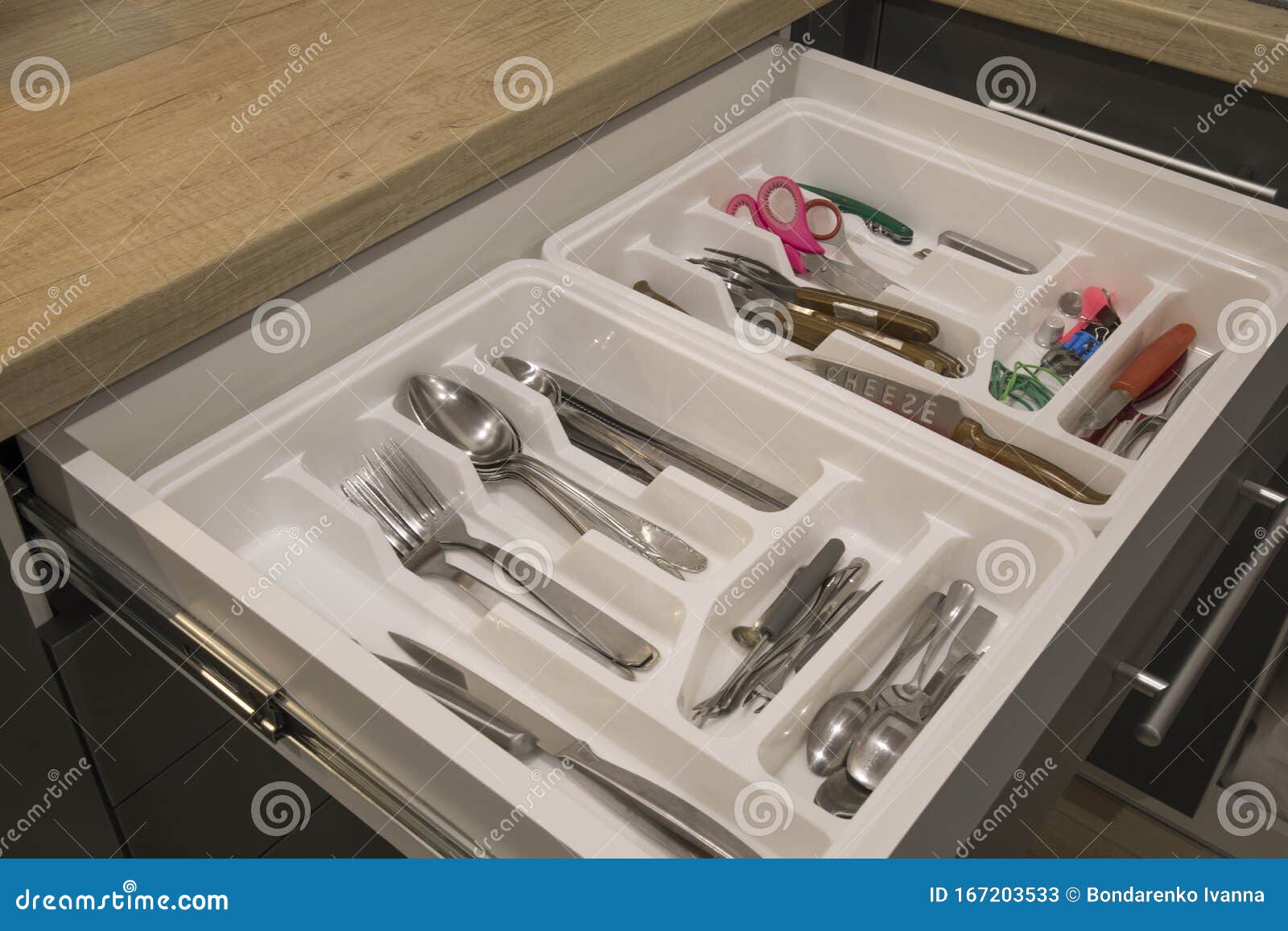 Opened Kitchen Drawer with a Tray and Cutlery Inside. Grey Front of the ...