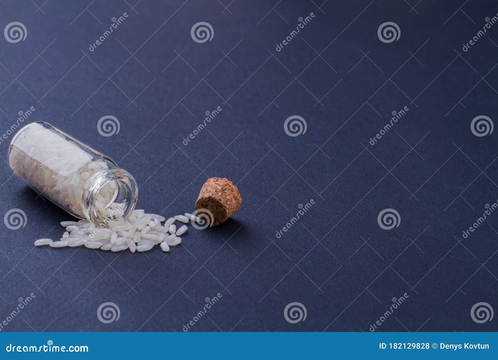 Opened Mini Bottle with Rice Lying on Dark Blue Surface. Stock Photo ...