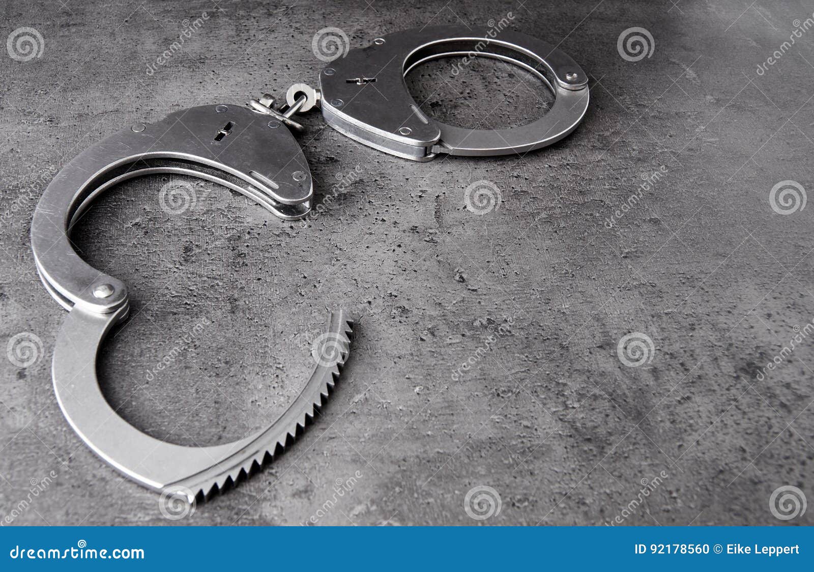 Opened Police Handcuffs on Rough Grey Background with Copy Space. Stock ...