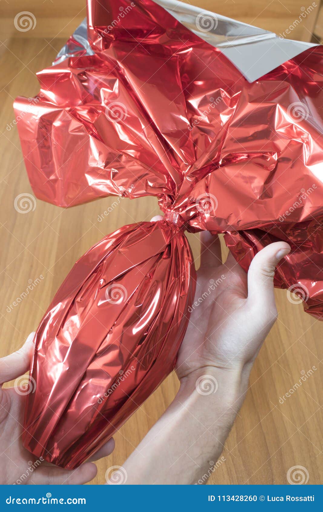 Opening an Easter Egg Made of Chocolate in a Red Wrapping Paper Stock ...