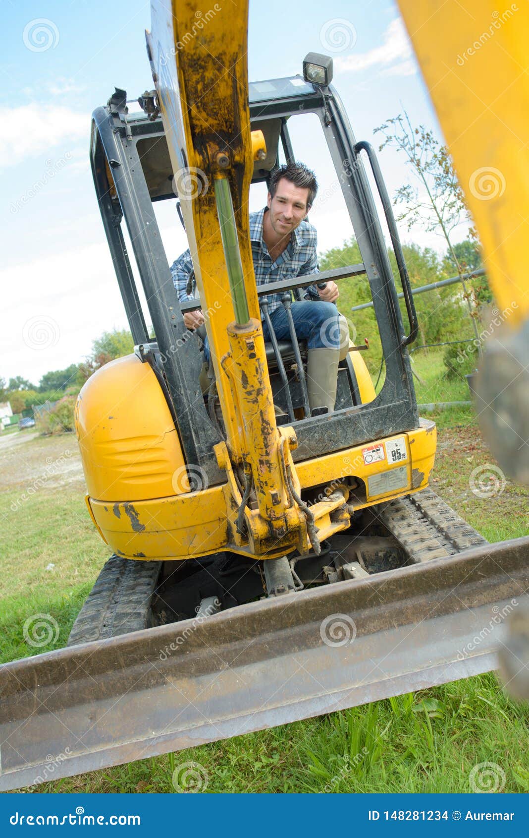 Operating a mini digger stock photo. Image of digger - 148281234