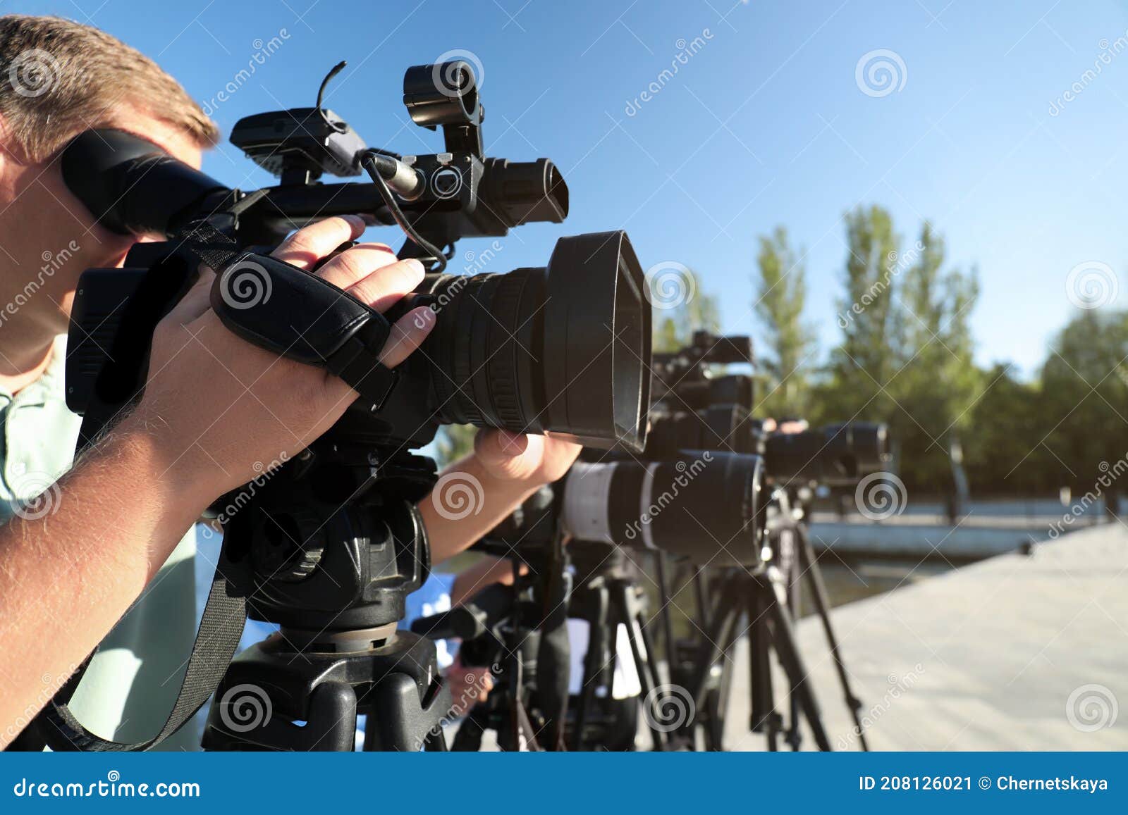 Operators with Professional Video Cameras Working Outdoors on Sunny Day ...