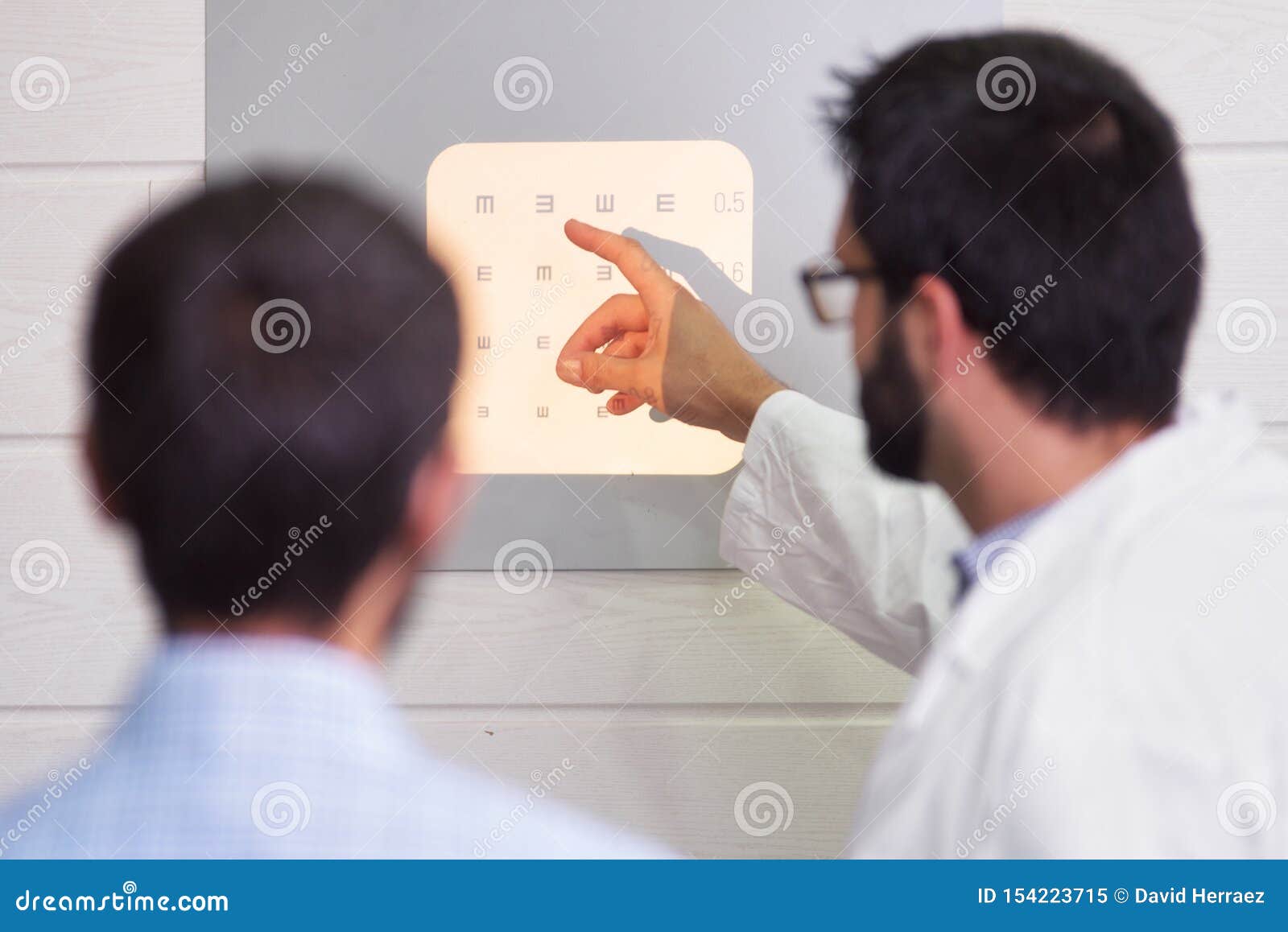 Ophthalmologist Pointing at Letters while Patient is Reading the Eye ...