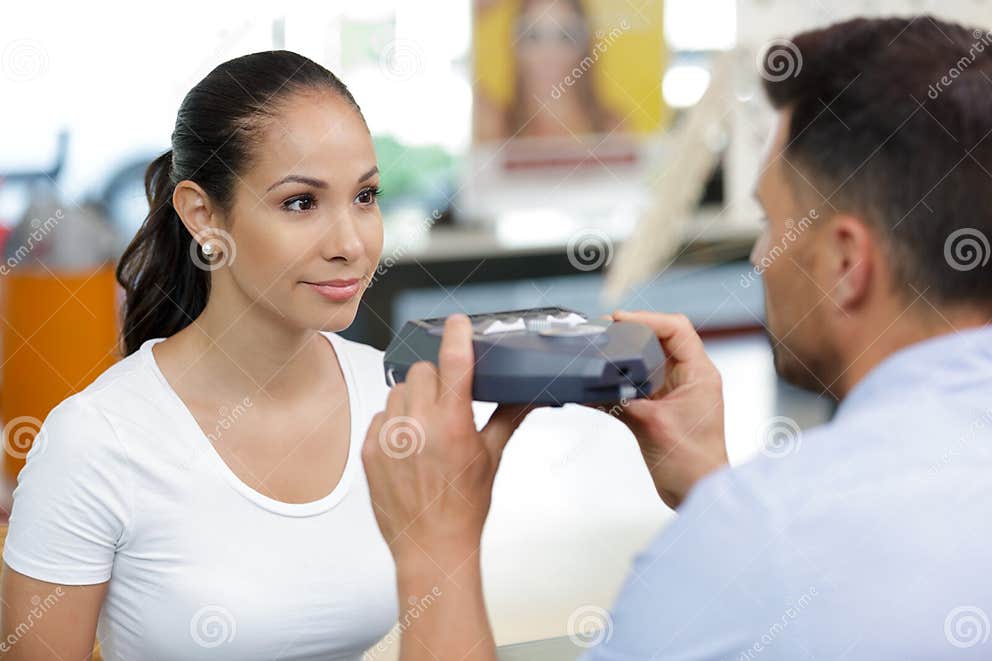 Optician Preparing To Use Handheld Device To Test Clients Vision Stock ...