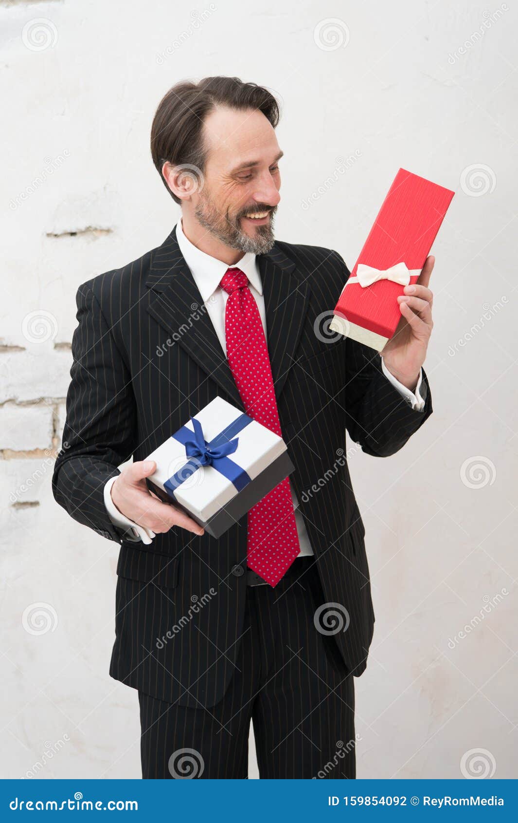 Optimistic Bearded Manager Choosing between Two Presents Stock Photo ...