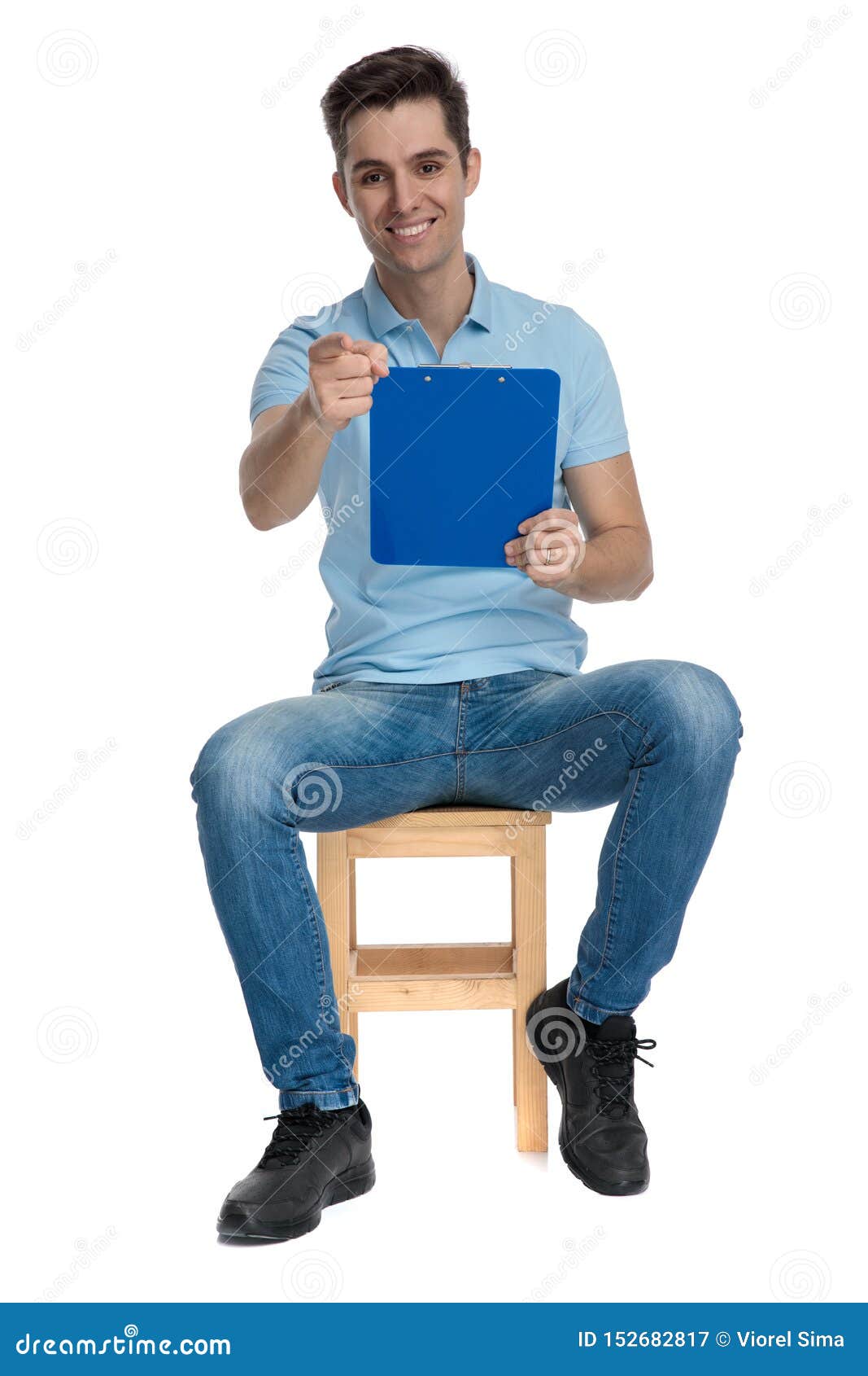 Optimistic Young Student Pointing and Holding a Blue Clipboard Stock ...