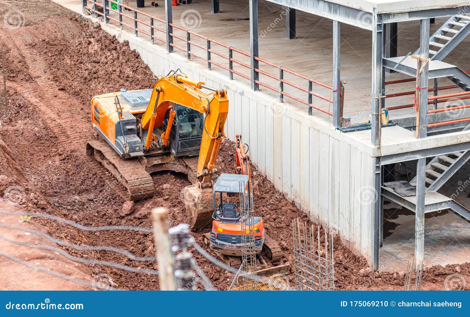 The Orange Backhoe and Mini Excavator is on the Ground at Site ...