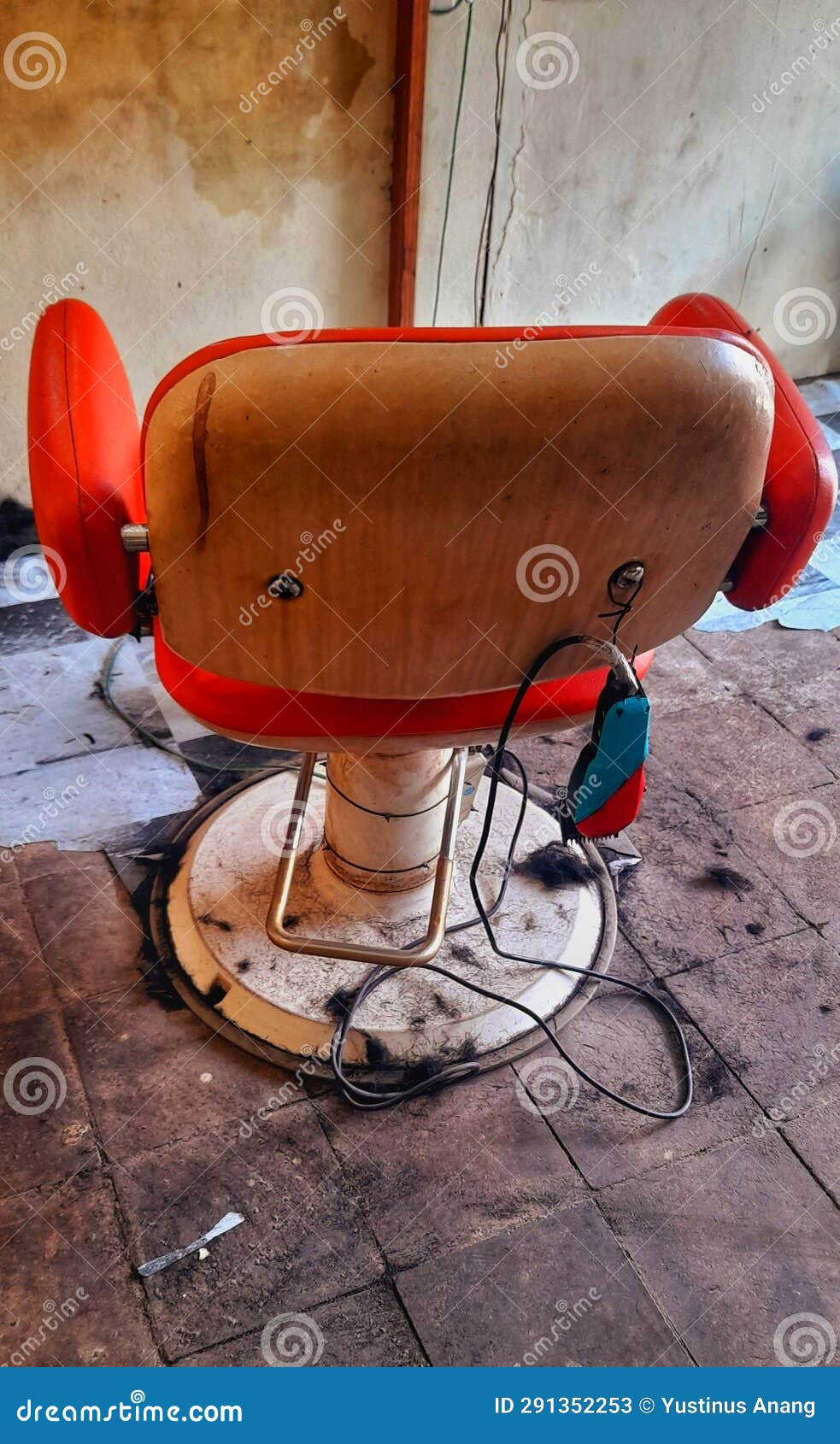An Orange Barber Chair is Visible from Behind and a Barber Machine and ...