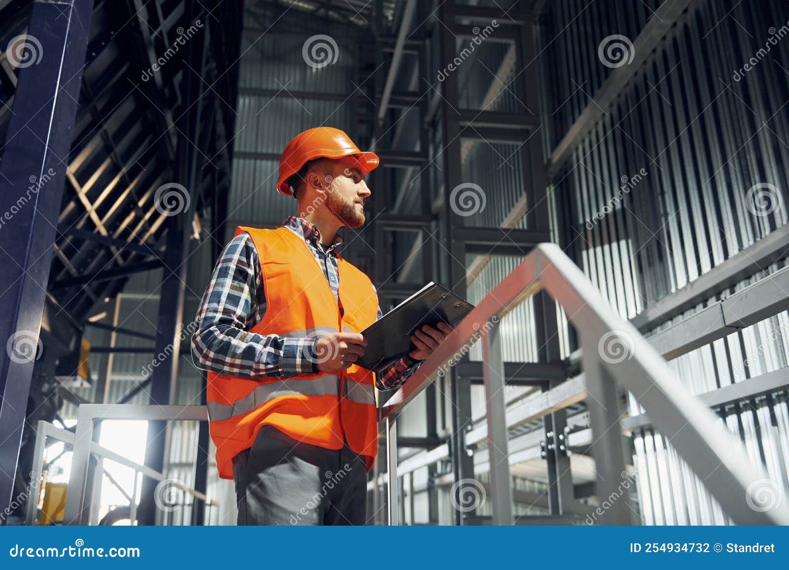 In Orange Colored Hard Hat. Construction Worker in Uniform is in the ...