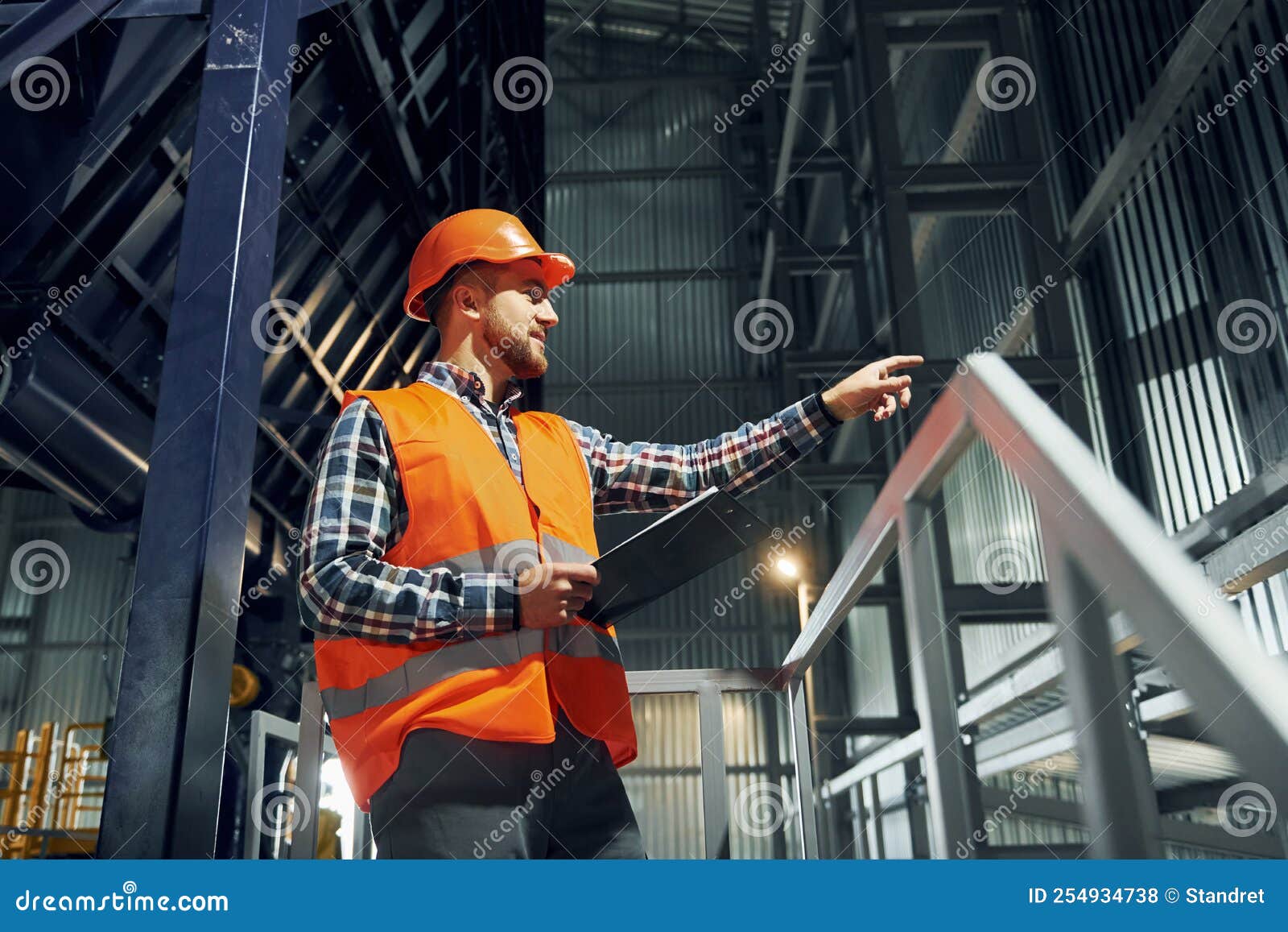 In Orange Colored Hard Hat. Construction Worker in Uniform is in the ...