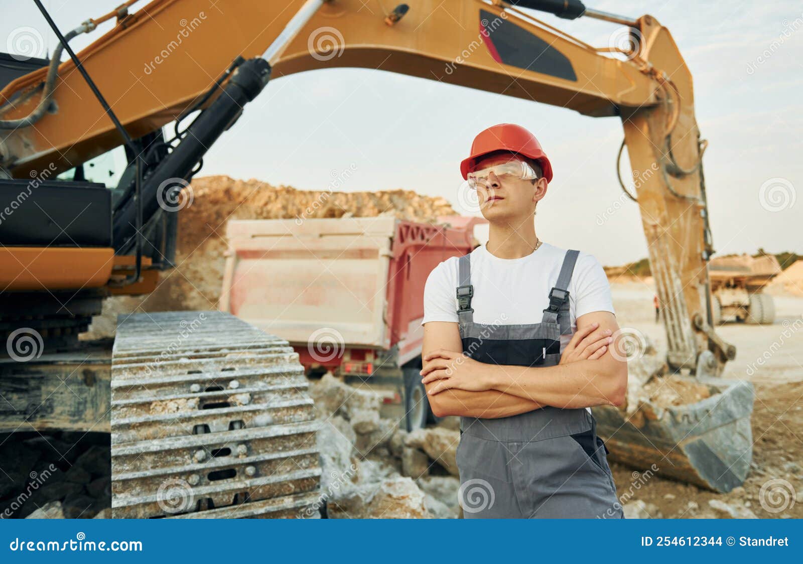 In Orange Colored Hard Hat. Worker in Professional Uniform is on the ...