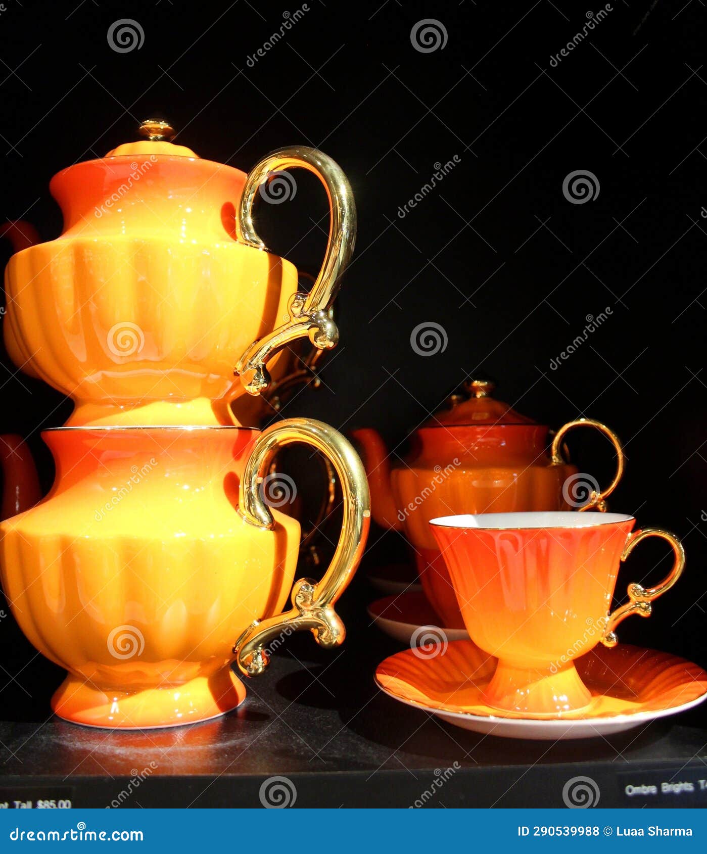 Orange Colored Tea Pots with Tea Cups Placed in a Shelf Stock Photo ...