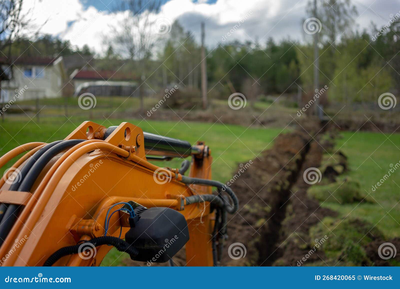 Orange Digger Digging the Ground of the House Backyard on the Blurred ...