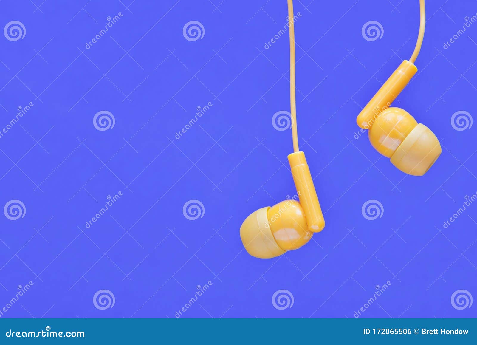 Orange Earbuds on a Plain Blue Background. Stock Photo - Image of ...
