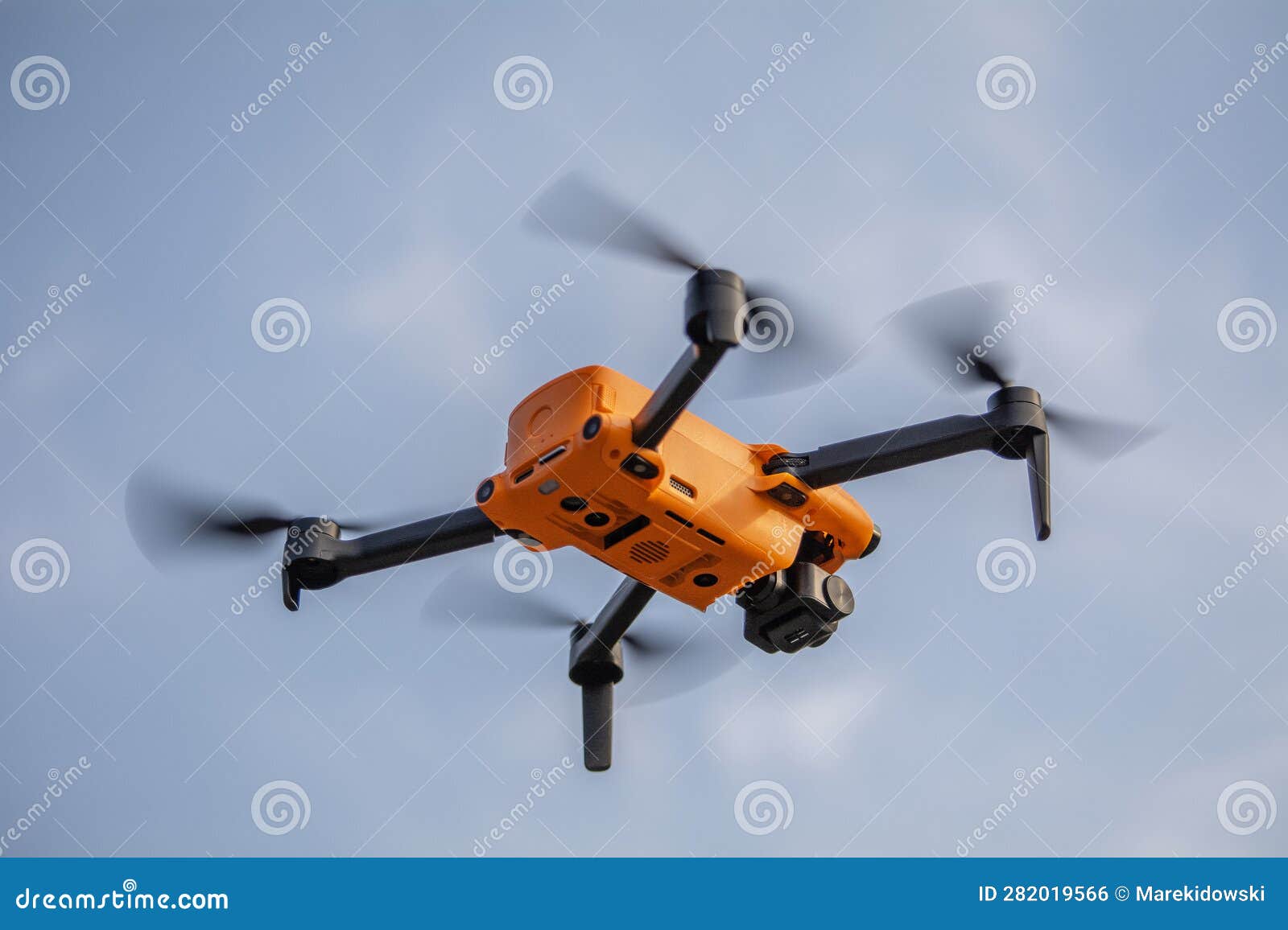 An Orange, Four-engined Drone in Flight. Stock Photo - Image of ...