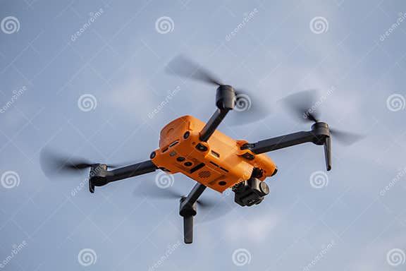 An Orange, Four-engined Drone in Flight. Stock Photo - Image of ...
