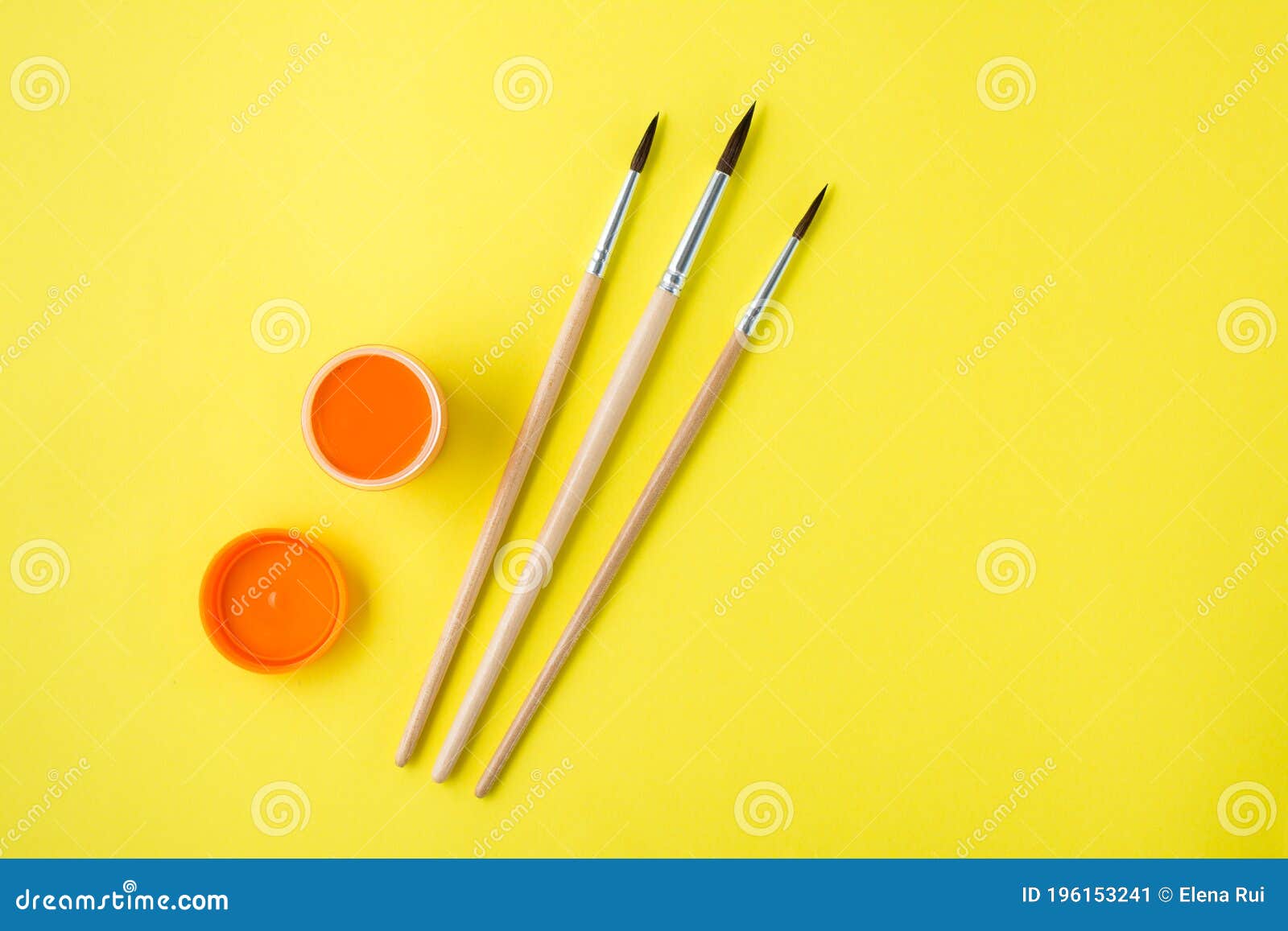Orange Gouache in an Open Jar and Brush on a Yellow Background ...
