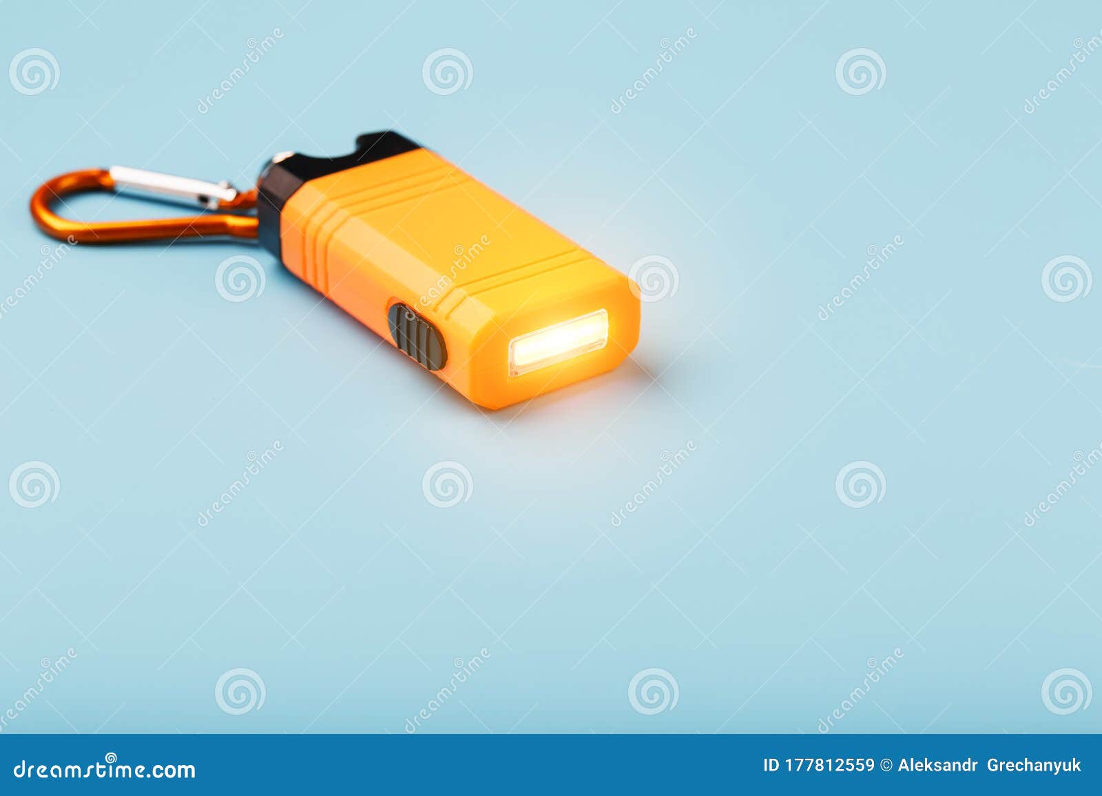 An Orange Led Flashlight with a Carabiner Glows on a Blue Background ...