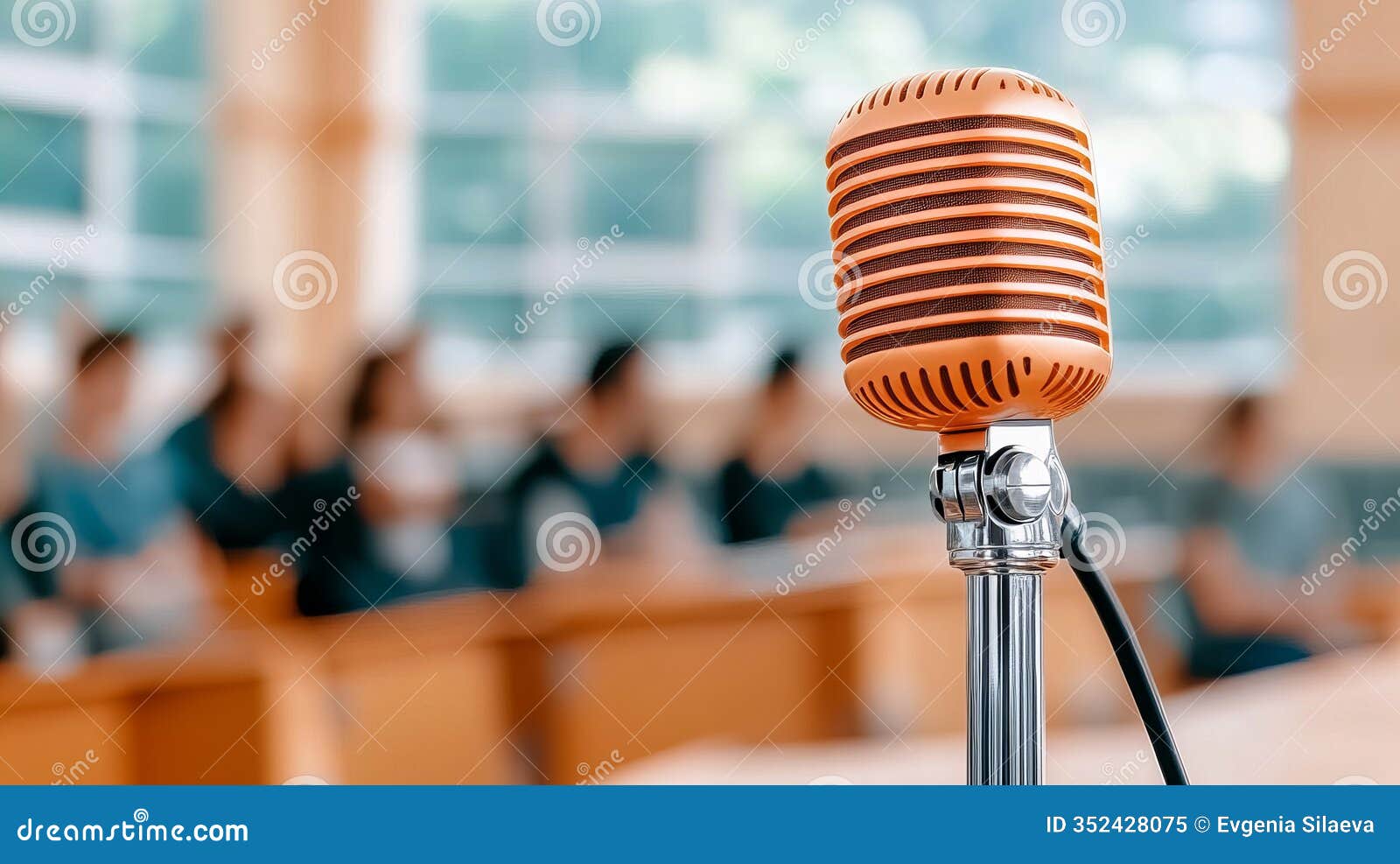 Orange Microphone in Conference Room with Defocused Audience in ...
