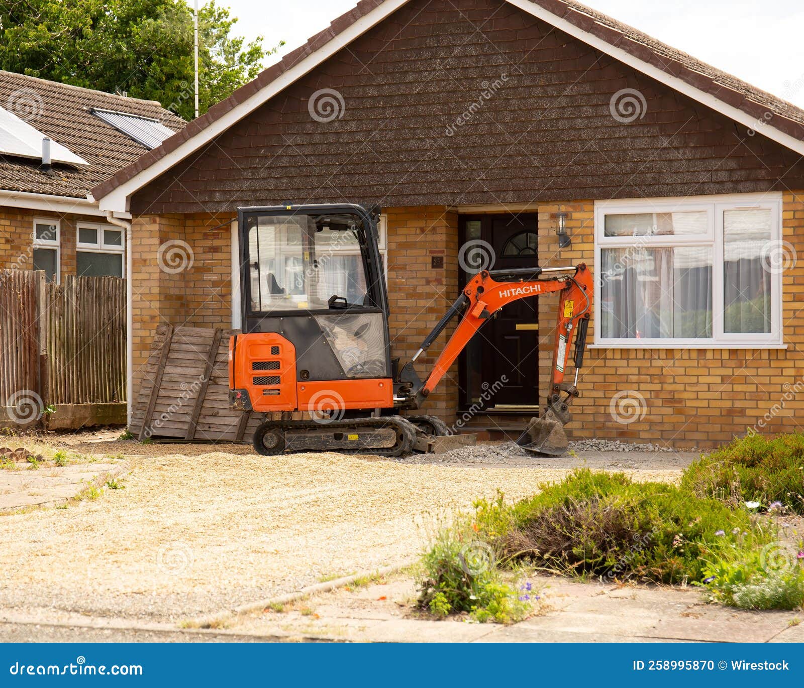 Orange Mini Excavator Digger Clearing Driveway in Front of Bungalow ...
