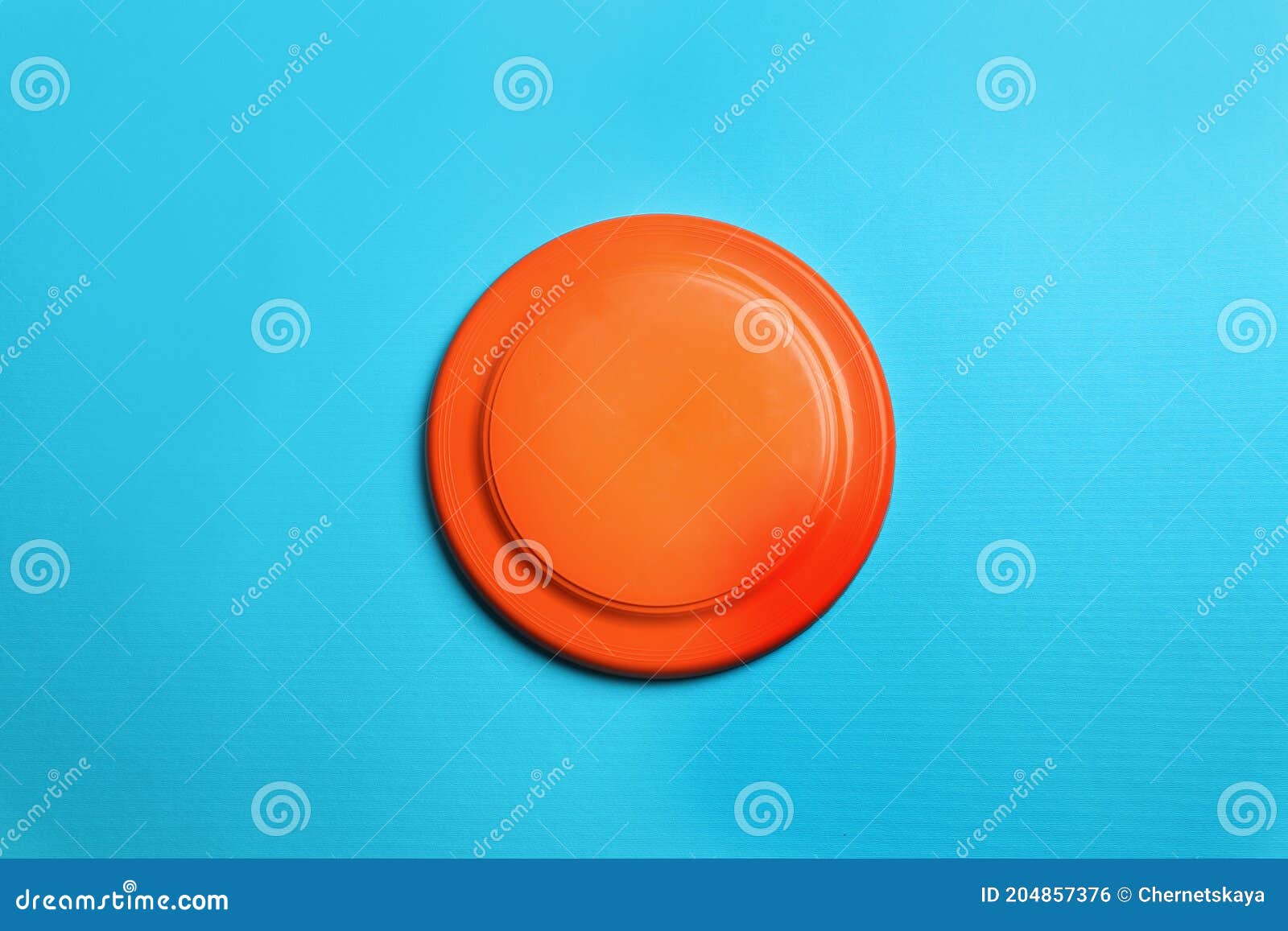 Orange Plastic Frisbee Disk on Light Blue Background, Top View Stock ...