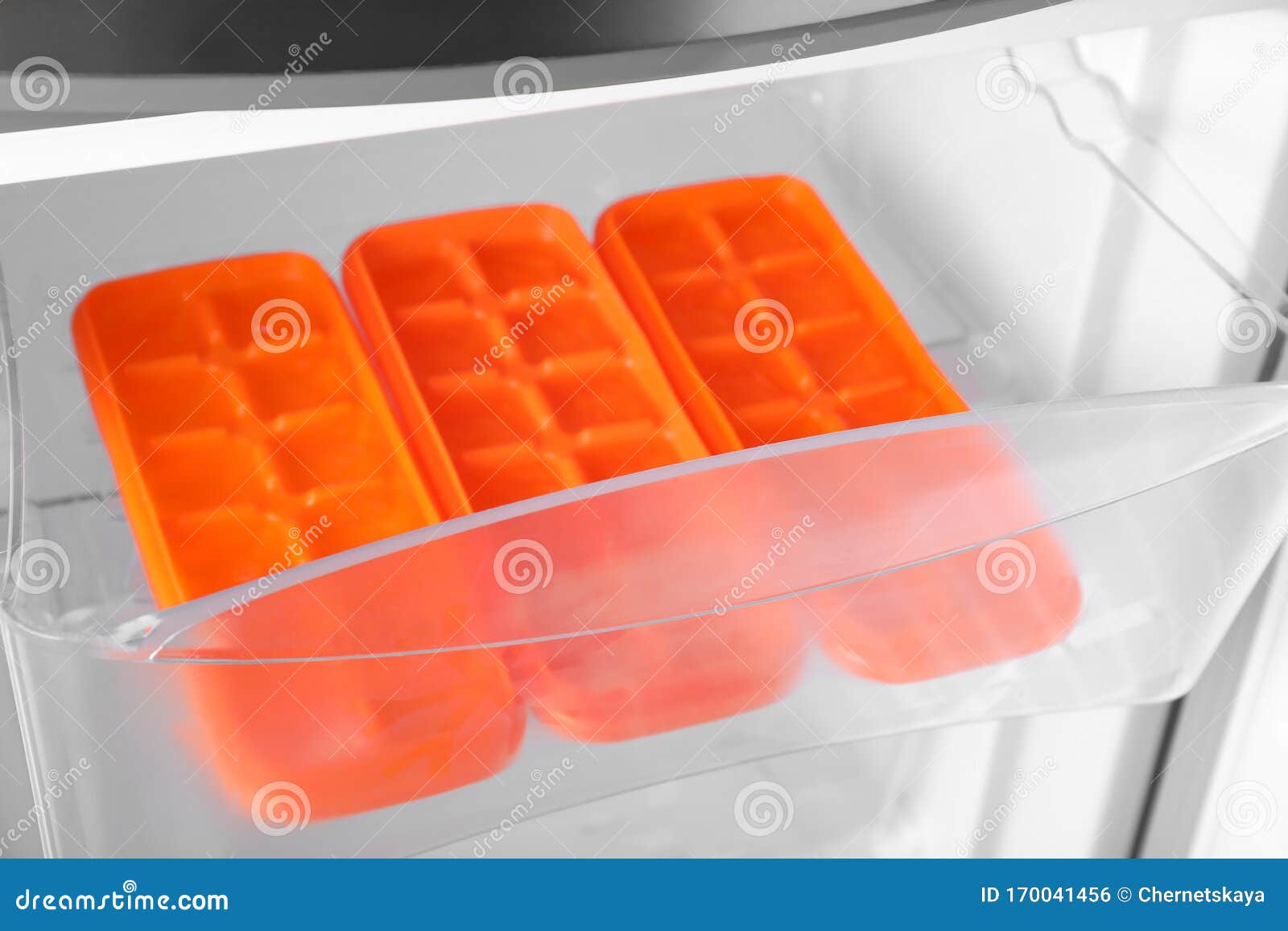 Orange Plastic Ice Cube Trays in Fridge Stock Photo - Image of drink ...