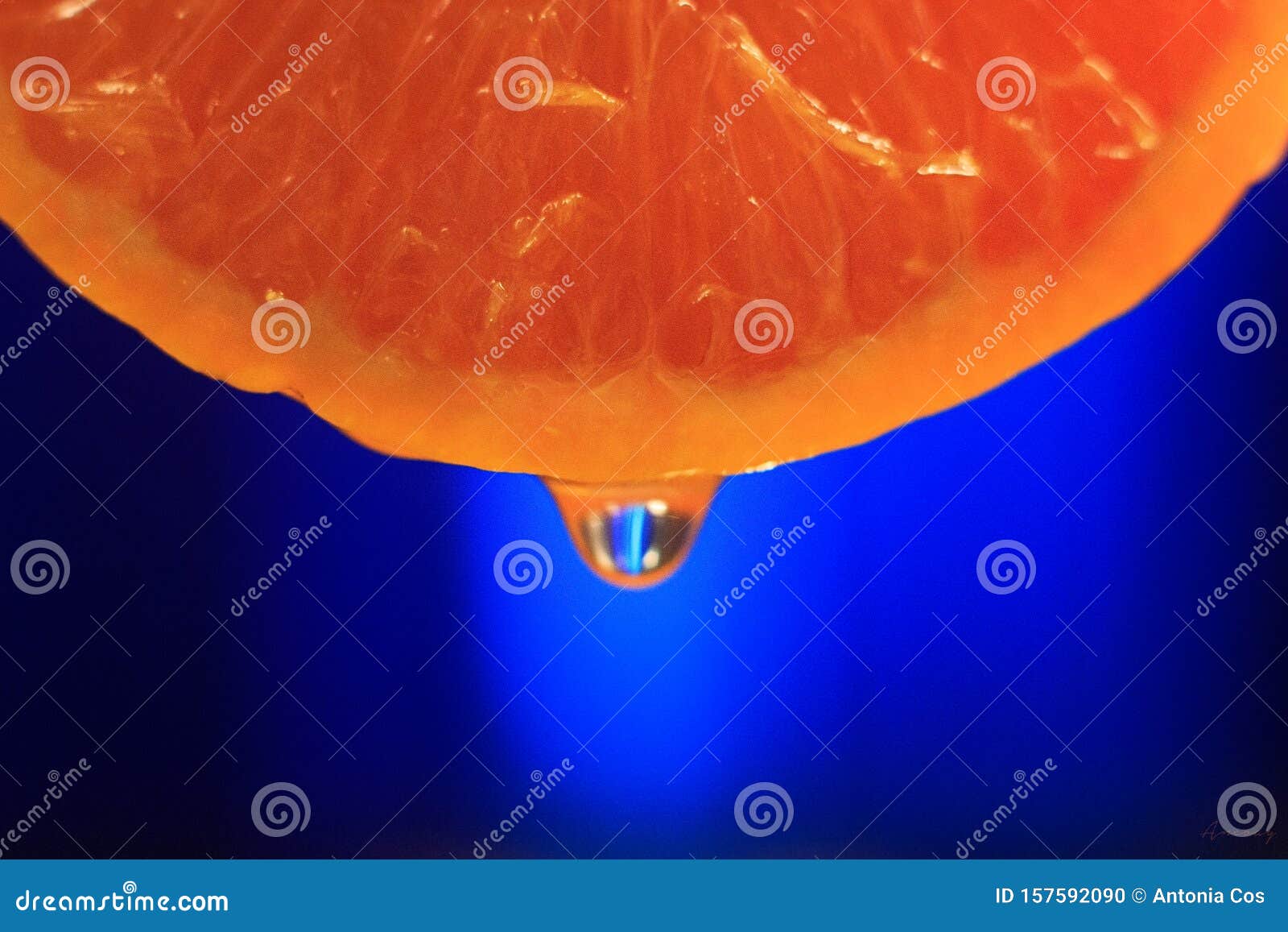 Orange Slice with Juice Drop and Blue Background Stock Photo - Image of ...