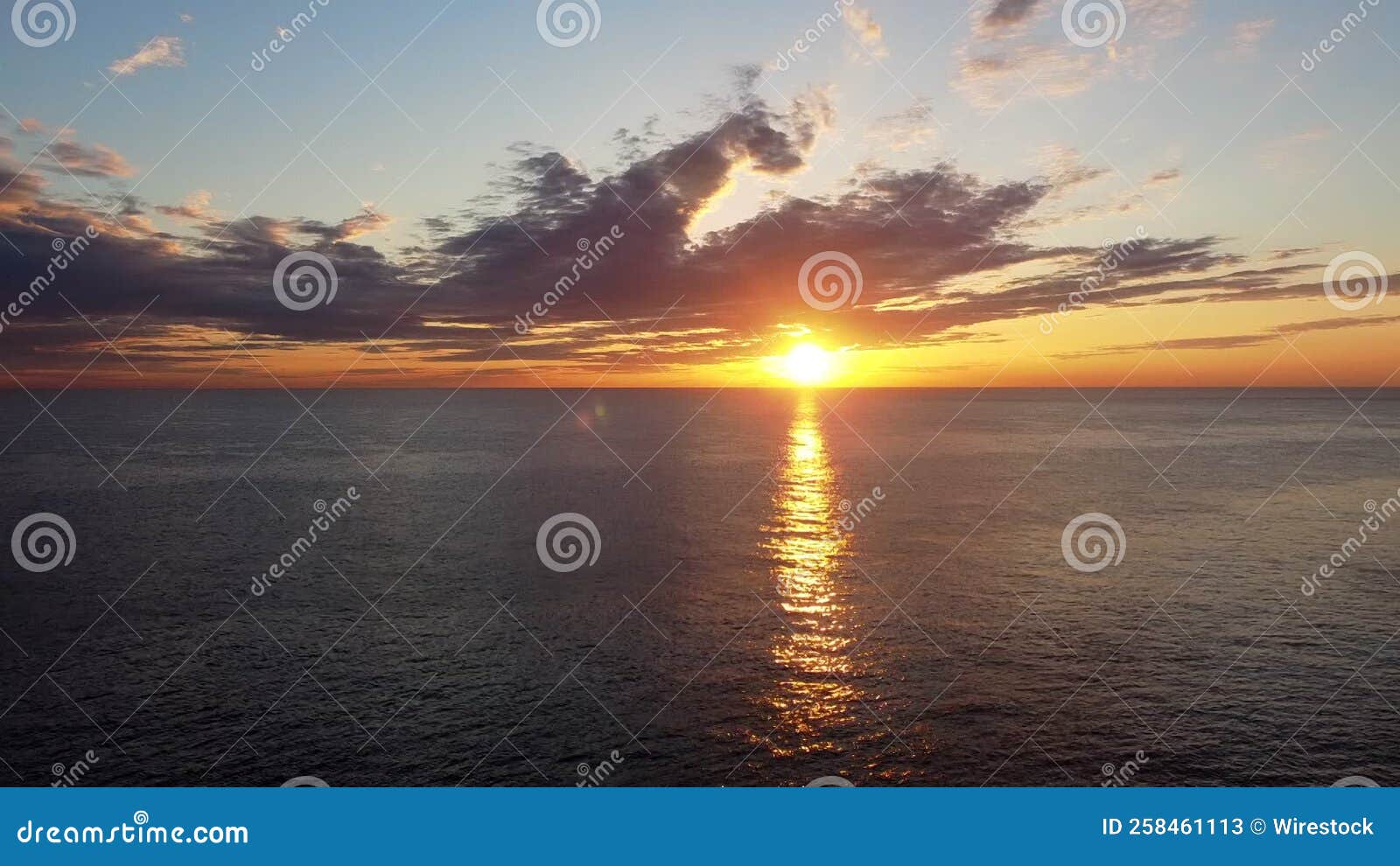 Orange Sunset Reflection on the Ocean Water with Cloudy Sky in the ...