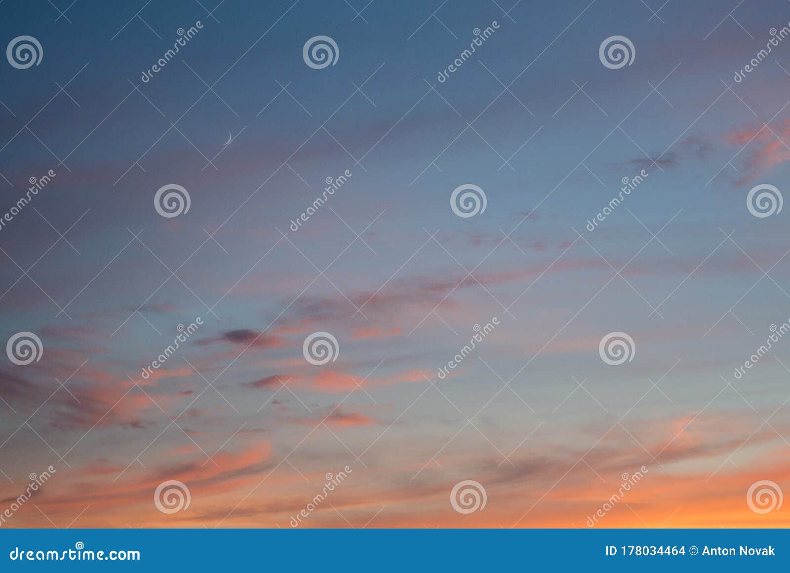 An Orange Sunset Sky with the Moon and Clouds Stock Photo - Image of ...
