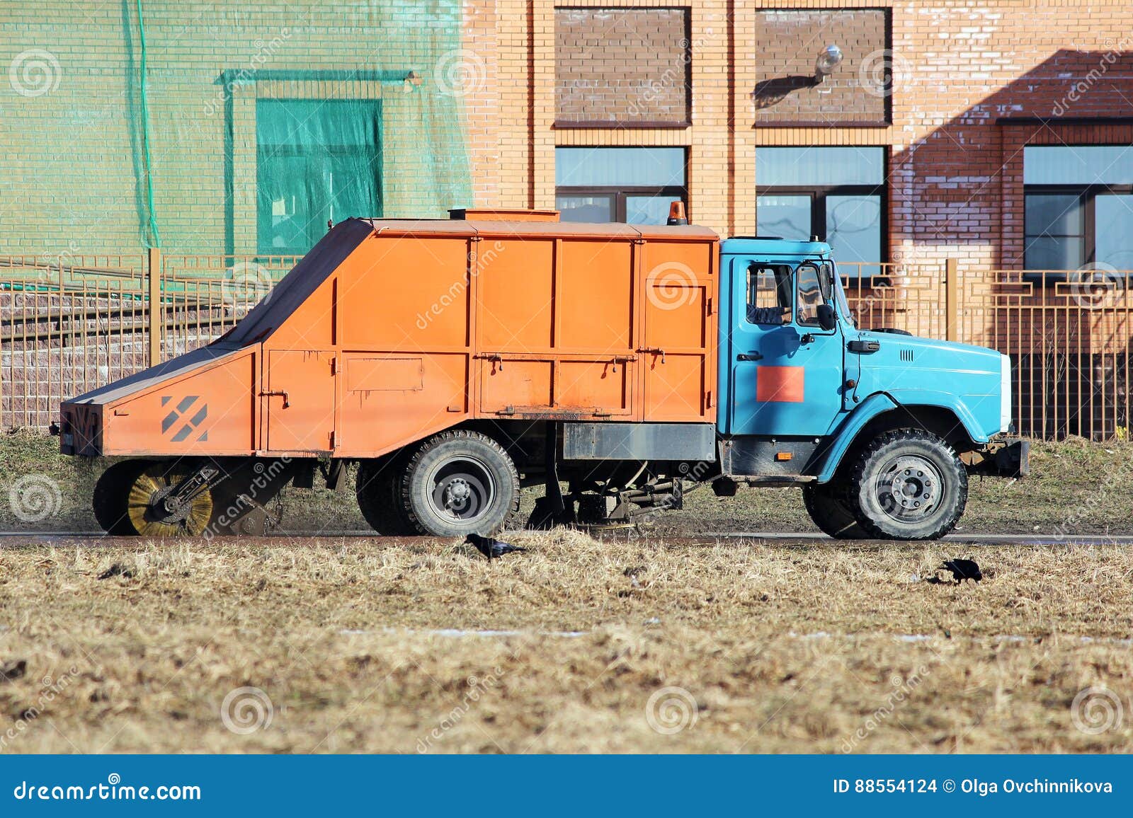 Orange Urban Sweeper Cleans Road from Dirt with a Round Brush in the ...