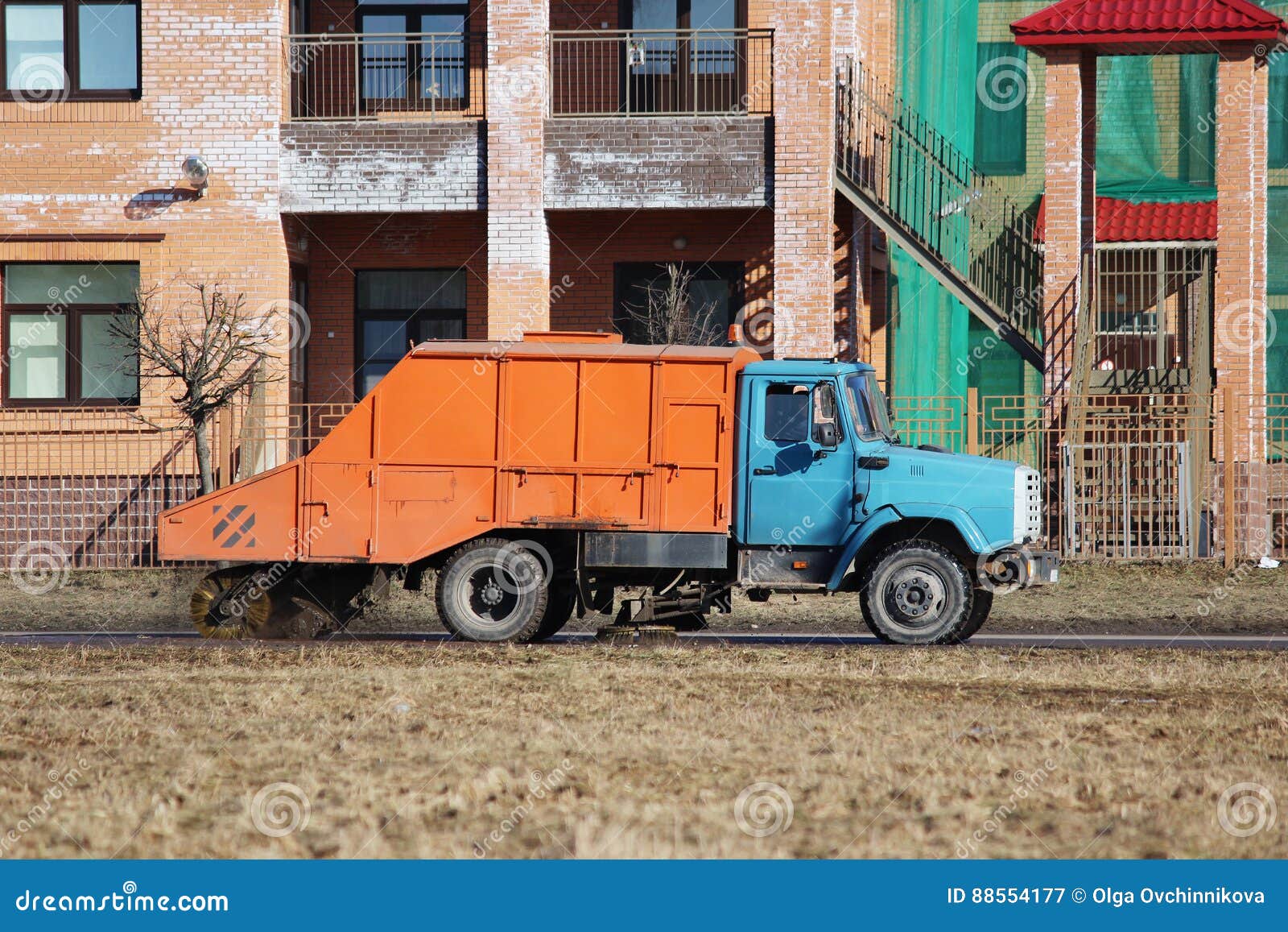 Orange Urban Sweeper Cleans Road from Dirt with a Round Brush in the ...