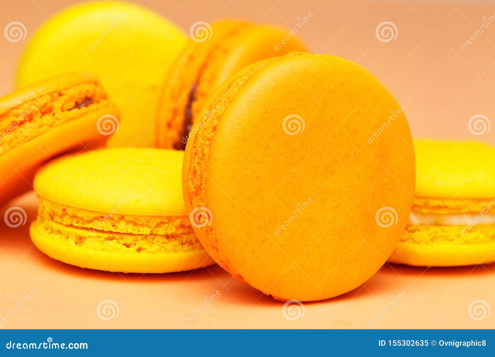 Orange and Yellow Macarons or Macaroons Stacked Over Pinky Orange ...