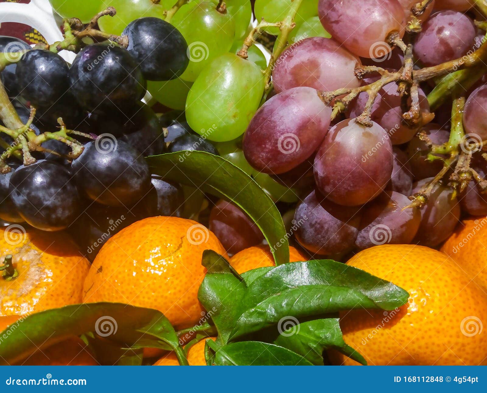 Natural Looking Oranges and Colorful Grapes in a Bucket Stock Photo ...