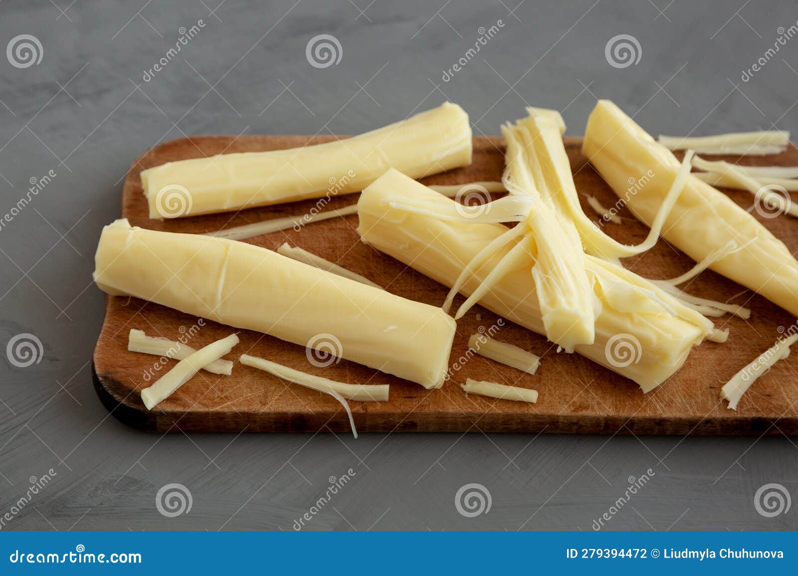 Organic String Cheese on a Rustic Wooden Board on a Gray Background ...